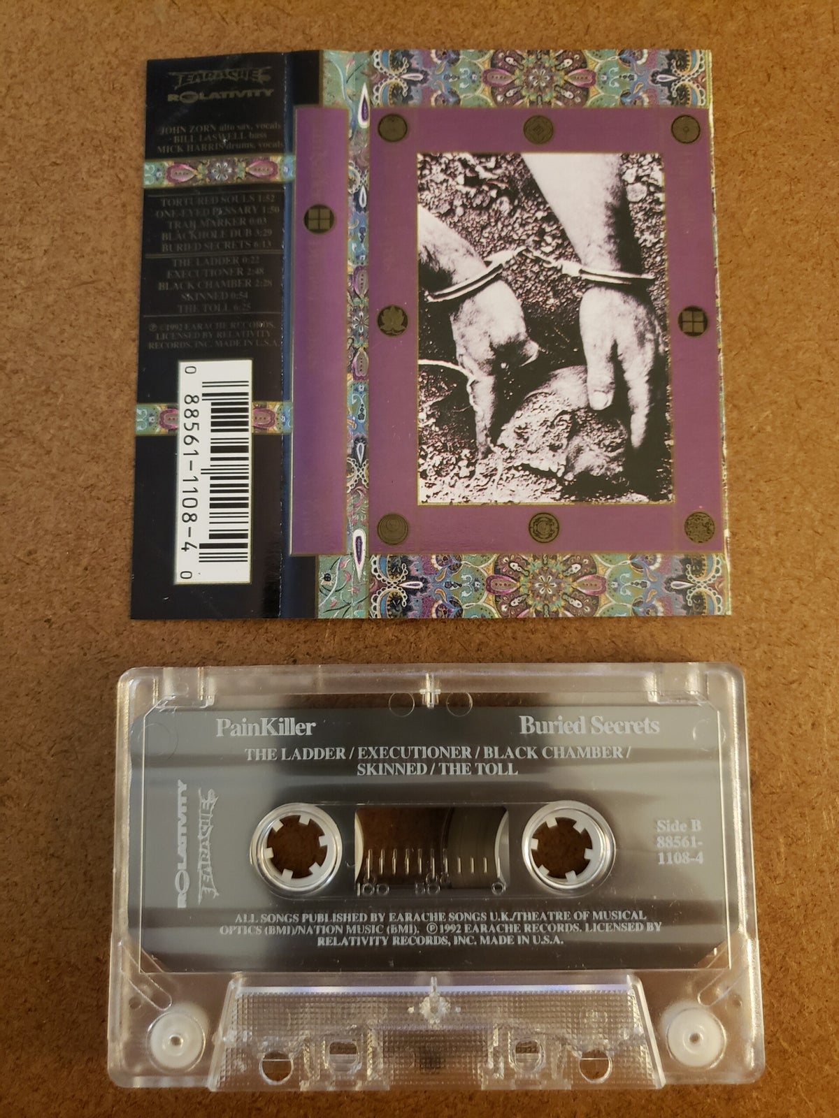 PAINKILLER - Buried Secrets Cassette | CATACOMBS OF DEATH